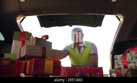 A delivery man loads up boxes to deliver to an apartment building on an ...