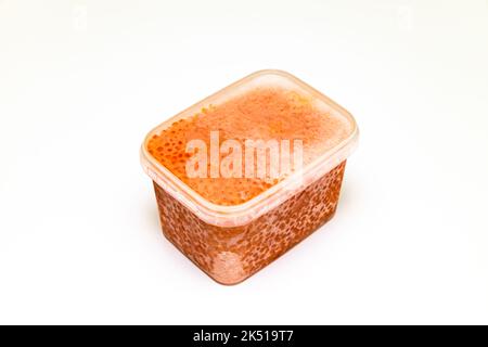 red caviar in a plastic container on a white background. High quality ...