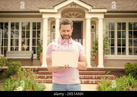 busy bearded man realtor buying house online on laptop, mortgage Stock ...