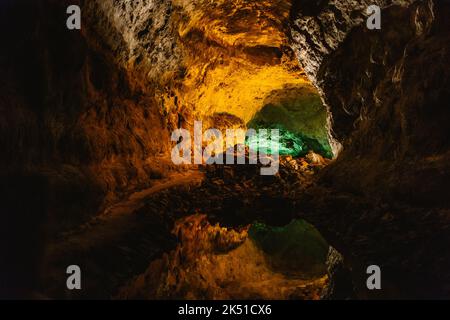 Crystal stalactites of emerald color hanging from rough ceiling of ...