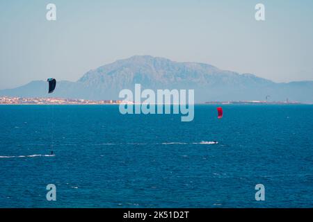 High angle of people windsurfing and parasailing on rippling turquoise ...