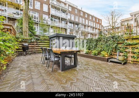 big and green terrace among buildings with table and chairs Stock Photo ...