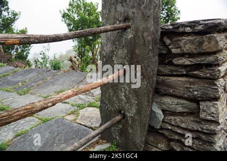 traditional stone gate or stile in a dry stone wall with flowers and ...
