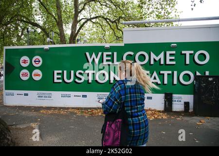 A woman walks past a 'Welcome to Euston Station' sign Stock Photo - Alamy