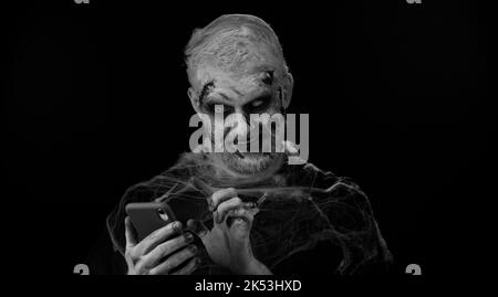 Frightening man Halloween zombie using mobile phone typing new post on ...