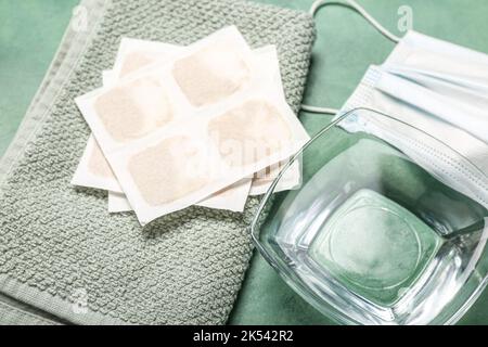 Mustard plasters with bowl of water, mask, thermometer and medicines on ...