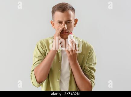 Young man with nosebleed and tissue on white background Stock Photo - Alamy