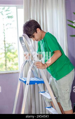 Portrait of a child climbing a stainless steel ladder. Skill at home ...