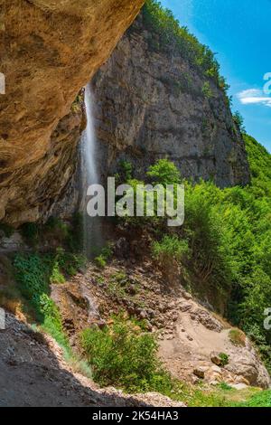 Traveler admires the view of waterfall in Iceland. Summer landscape on ...