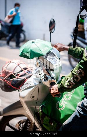 A Grab bike courier arrives to pick up a parcel in Bangkok Thailand ...