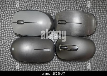 four different wireless mice on a black background Stock Photo - Alamy