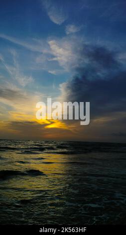 A vertical shot of the beautiful sunset at Kerala public property beach ...