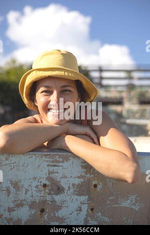A young woman posing on a pebble beach in a beige swimsuit and open ...