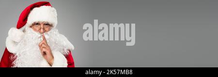 Santa Claus showing shh secret gesture on Christmas eve sitting at home ...