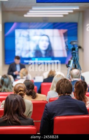 People against screen with online speaker Stock Photo - Alamy
