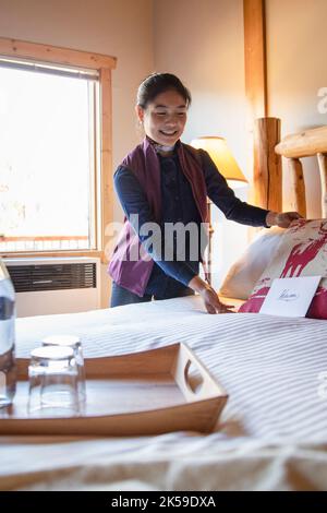 Young asian hotel maid making the bed. Show rating of service ...