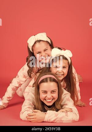 Pajama party is a real laugh. Happy sisters laughing lying close on each other. Laugh and be ...