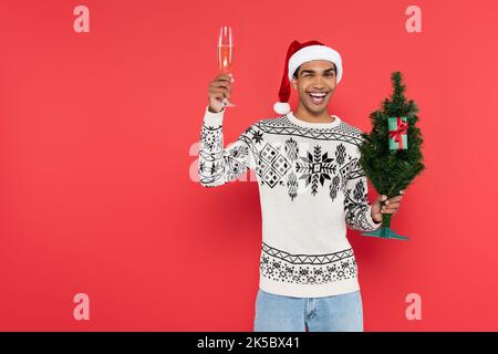 winking man with present isolated on yellow background. present box for ...