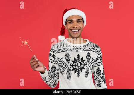Cheerful man with sparkler looking at camera on blue background Stock ...