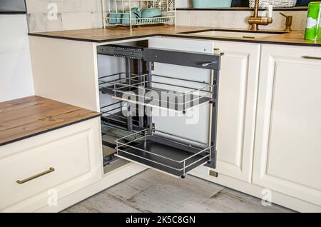 Retractable metal shelves in kitchen furniture Stock Photo - Alamy