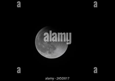 The Moon, with Earth's shadow draping across it during a lunar eclipse ...