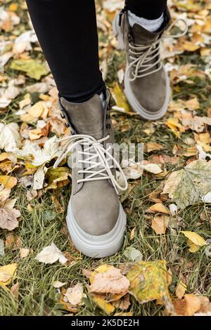 Women's leather shoes. Slender female legs in beige leather boots ...