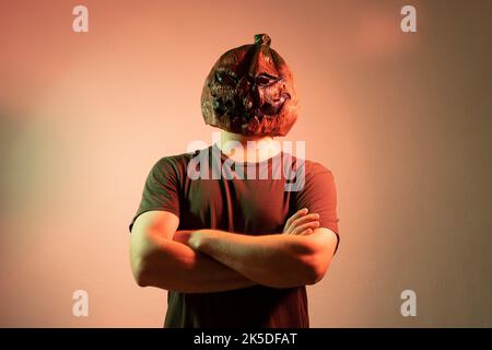 A man with a scary pumpkin mask is raising his fists - Halloween ...