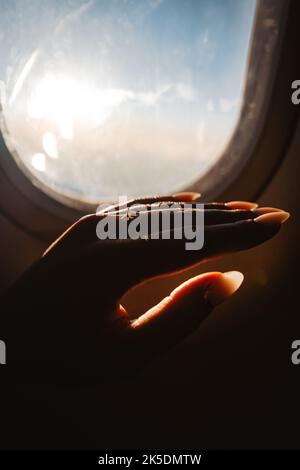 A vertical closeup of a female hand with a plane ring on the ring ...