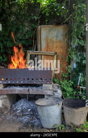 a fire in an old brazier in a dump of things Stock Photo - Alamy