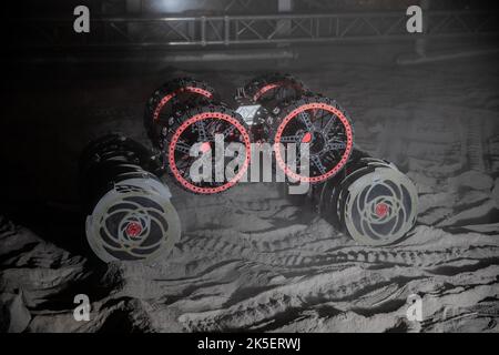 The ISRU Pilot Excavator digs in the regolith bin during testing inside ...