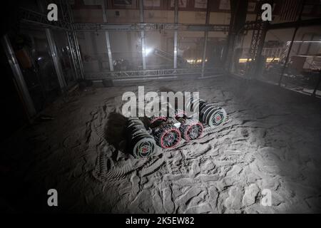 The ISRU Pilot Excavator digs in the regolith bin during testing inside ...
