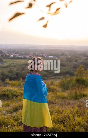Happy free ukrainian woman with national flag on dramatic sky ...