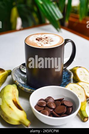 Banana chocolate latte with fresh banana and chocolate drops on white ...