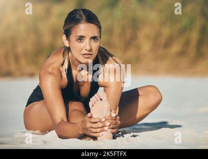 A female yogi does stretching in nature. Leg thrown to the head Stock ...