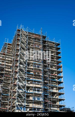 Scaffolded high-rise residential building with balconies and satellite ...