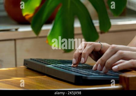 young mexican latina woman, typing on a wireless keyboard on her ...