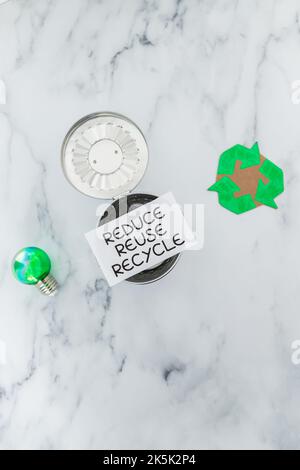 reduce reuse recycle sign with mini trash can next to recycle icon ...