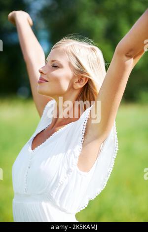 Young woman smiling and taking a deep breath in living room at morning ...