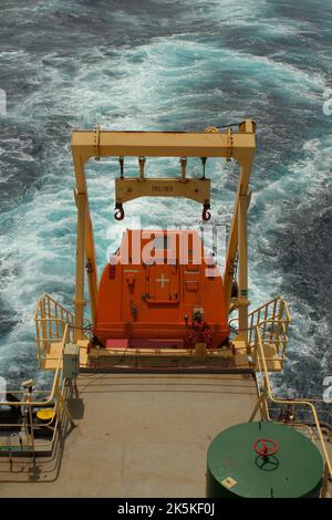 Aft of orange free fall lifeboat with door secured on launching ramp ...