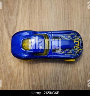 The top view of a blue Mattel Hot Wheels toy car on a wooden surface ...