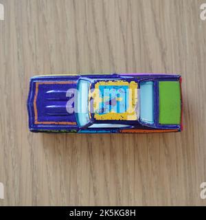 The top view of a blue Mattel Hot Wheels toy car on a wooden surface ...