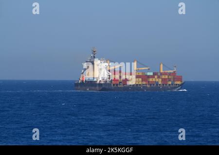 Merchant ship carrying container is underway at sea in calm weather ...