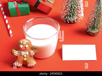 Milk glass with drinking straw, gingerbread man and empty white note on ...