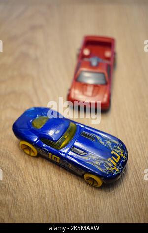 A vertical closeup of Mattel Hot Wheels toy model Nissan car on wooden ...