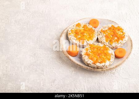 Carrot jam with puffed rice cakes on gray concrete background. Top view ...