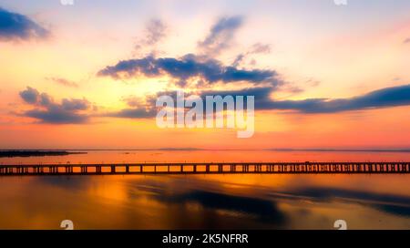 A scenic view of Shishu lake and bridge at sunset with the yellow ...