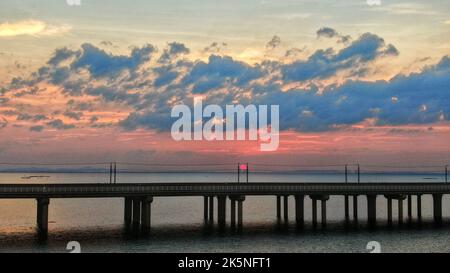 A scenic view of Shishu lake and bridge at sunset with the yellow ...