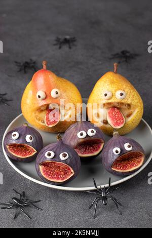 Spooky pear and fig monsters for Halloween party on wooden board ...
