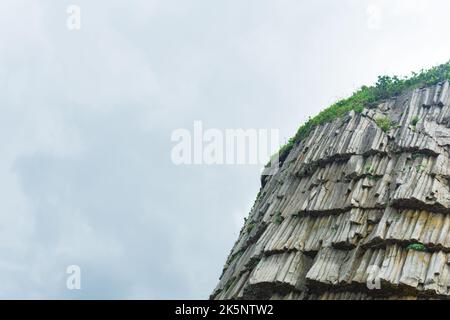 top of columnar volcanic basalt cliff against the background of the sky ...