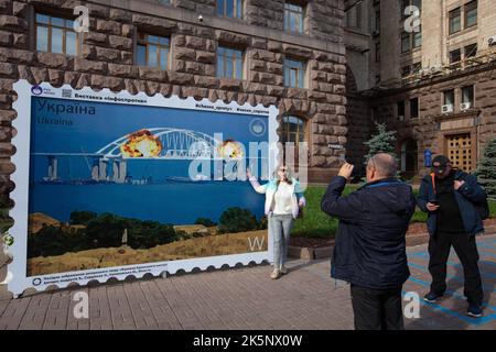 People are photographed with a stamp model depicting the burning ...
